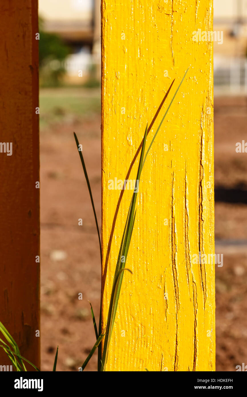 Yellow fence post of a playground. Vertical image Stock Photo - Alamy