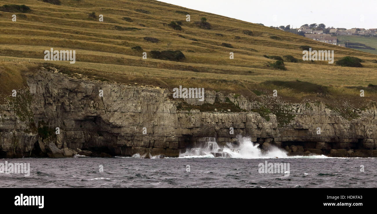 Waves lightly pounding limestone cliff structure with 'strip lynchets ...