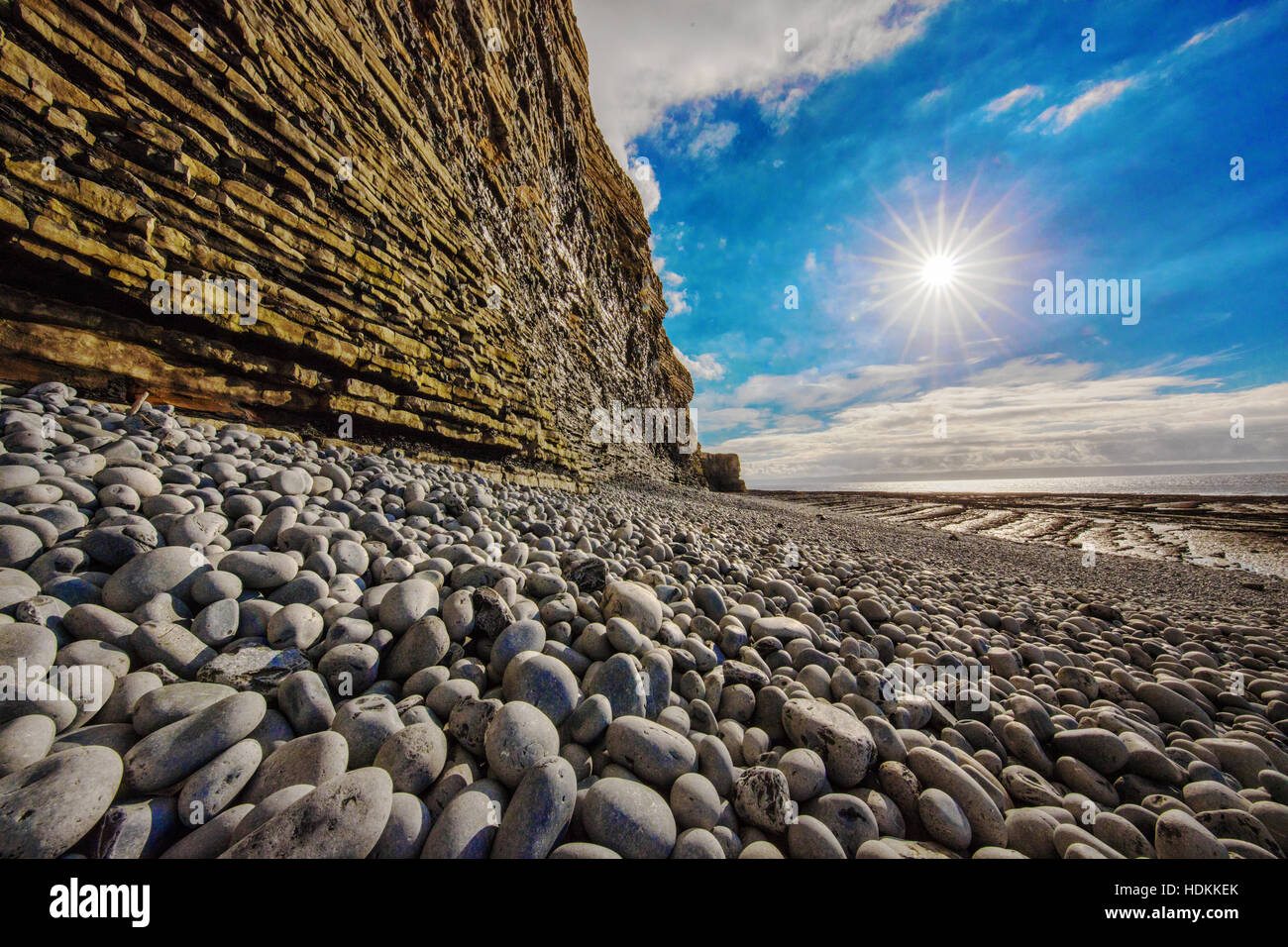 Boulder beach below Jurassic Lias limestone cliffs with Nash Point in ...
