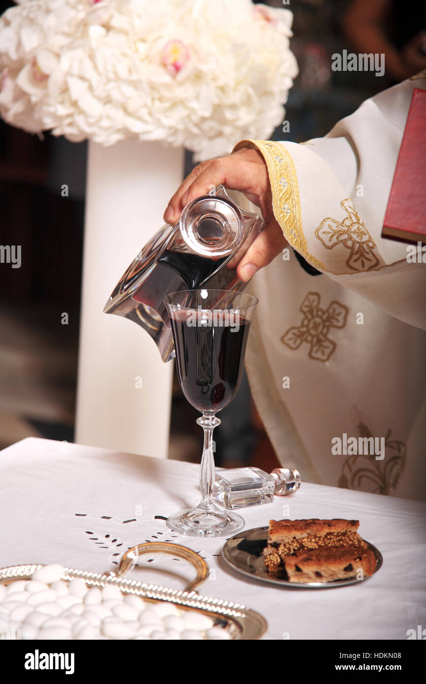 priest add red wine on a glass for the wedding Stock Photo - Alamy
