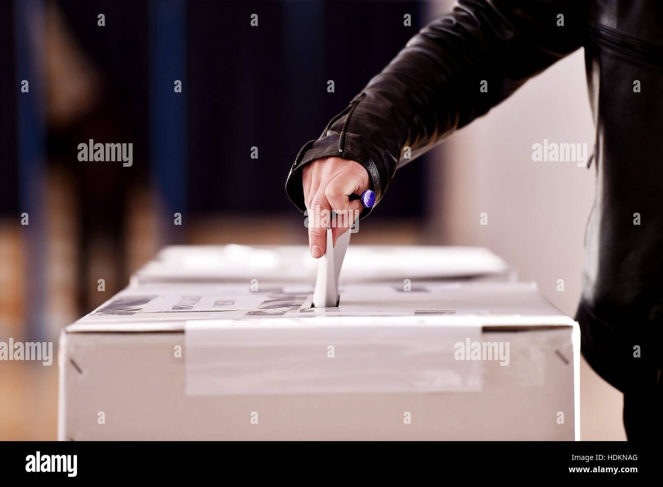 Hand of a person casting a vote into the ballot box during elections ...