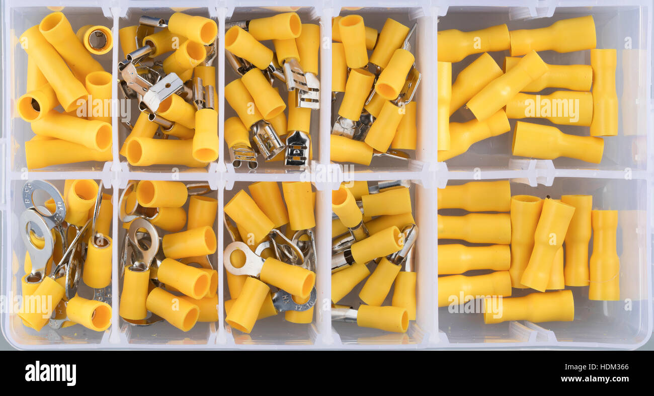 Yellow electric terminal connectors organized in plastic container ...