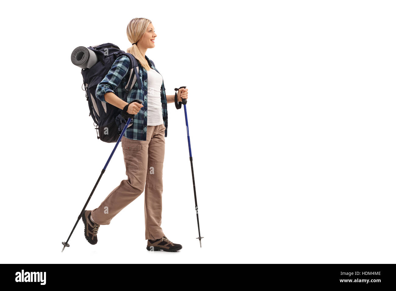 Full length profile shot of a woman with hiking equipment walking ...