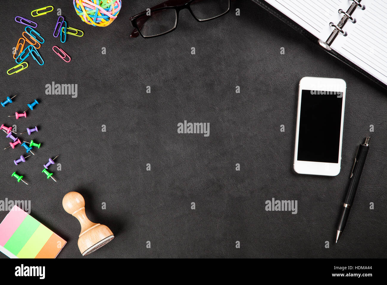 Office supplies on a black table Stock Photo - Alamy