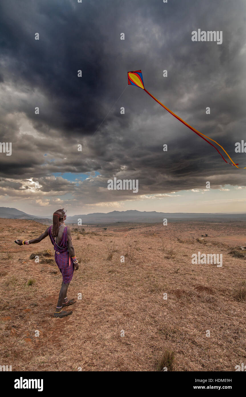 Maasai tribesman teaching a child to fly a kite. Kenya, Africa Stock ...