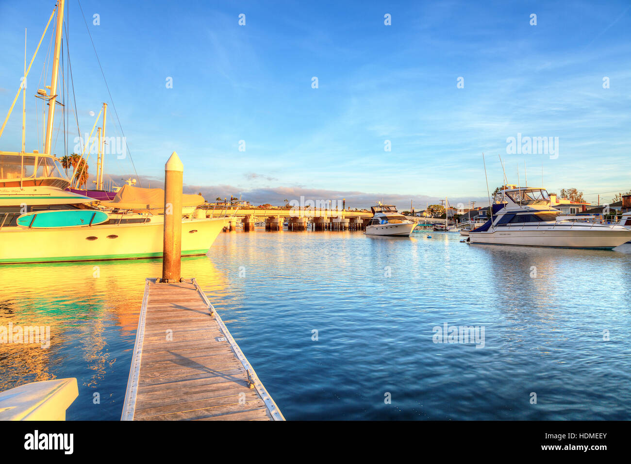 Balboa Island harbor at sunset with ships and sailboats visible from ...