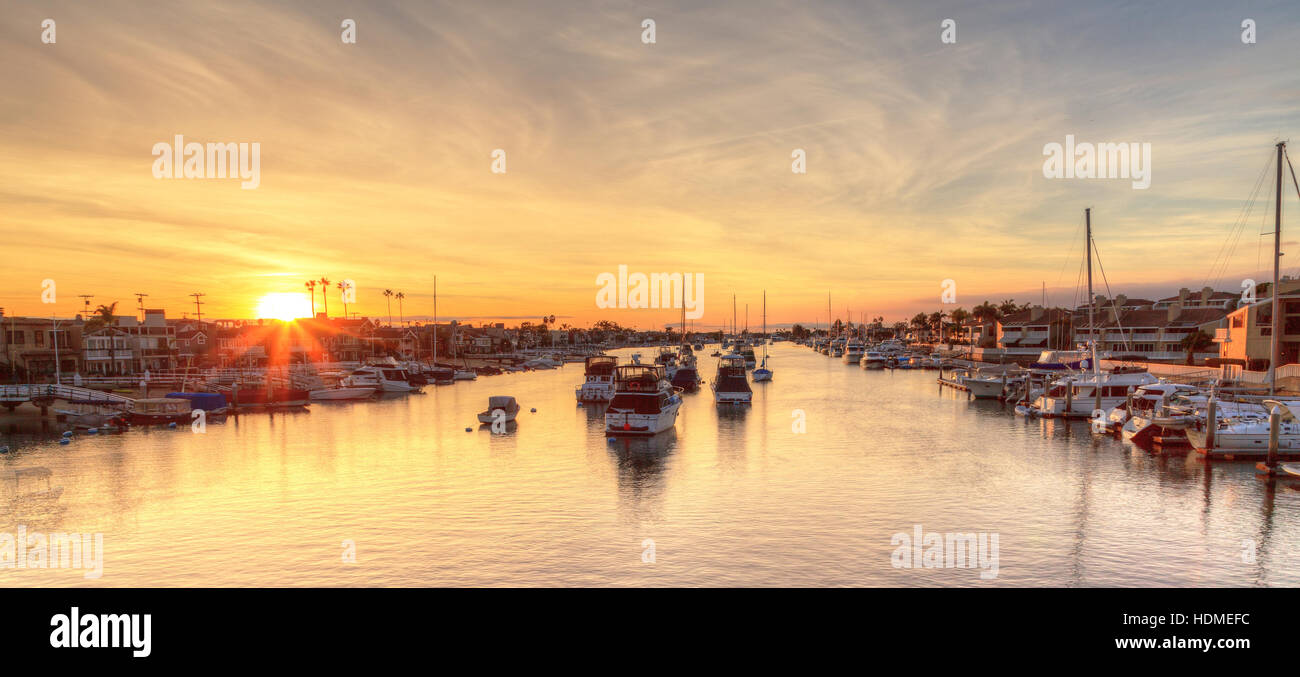 Balboa Island harbor at sunset with ships and sailboats visible from ...