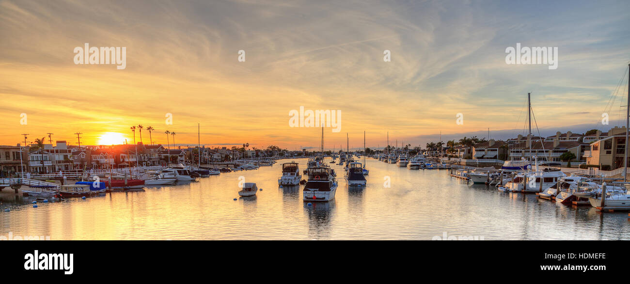 Balboa Island harbor at sunset with ships and sailboats visible from ...