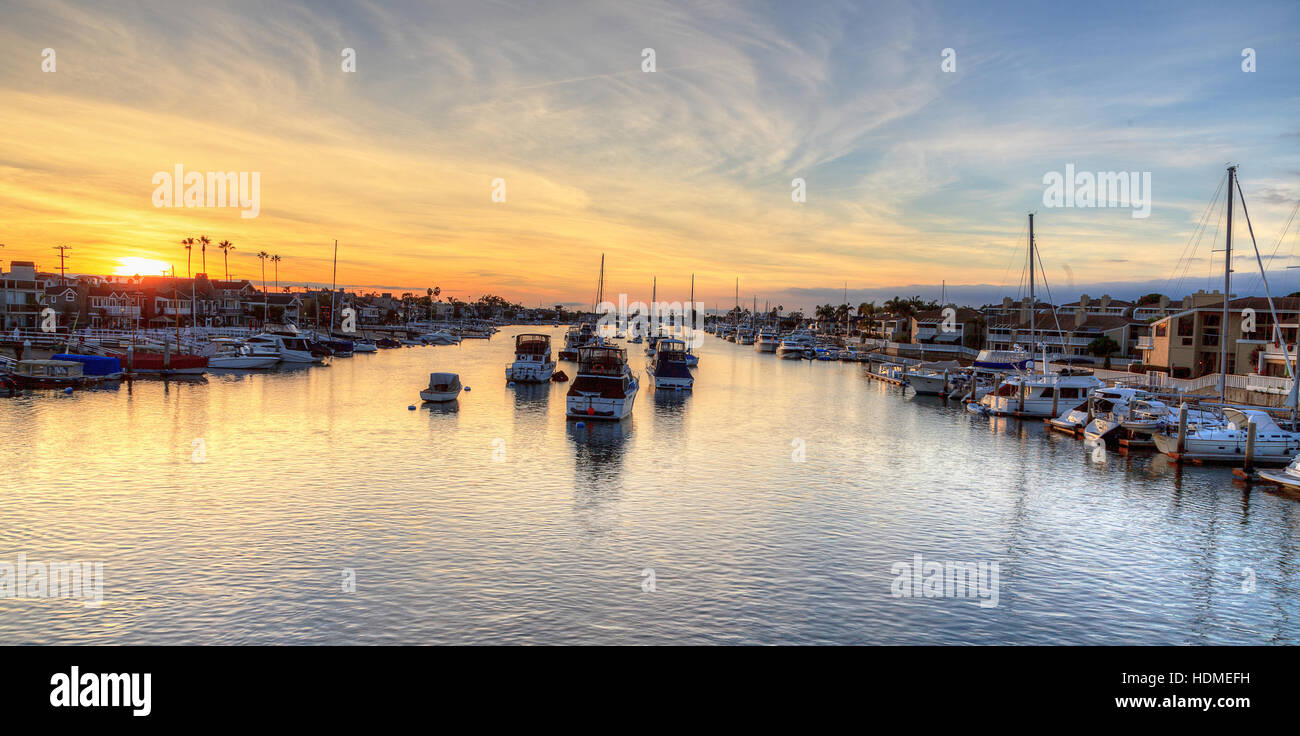 Balboa Island harbor at sunset with ships and sailboats visible from ...
