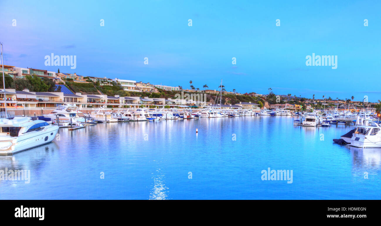 Balboa Island harbor at sunset with ships and sailboats visible from ...