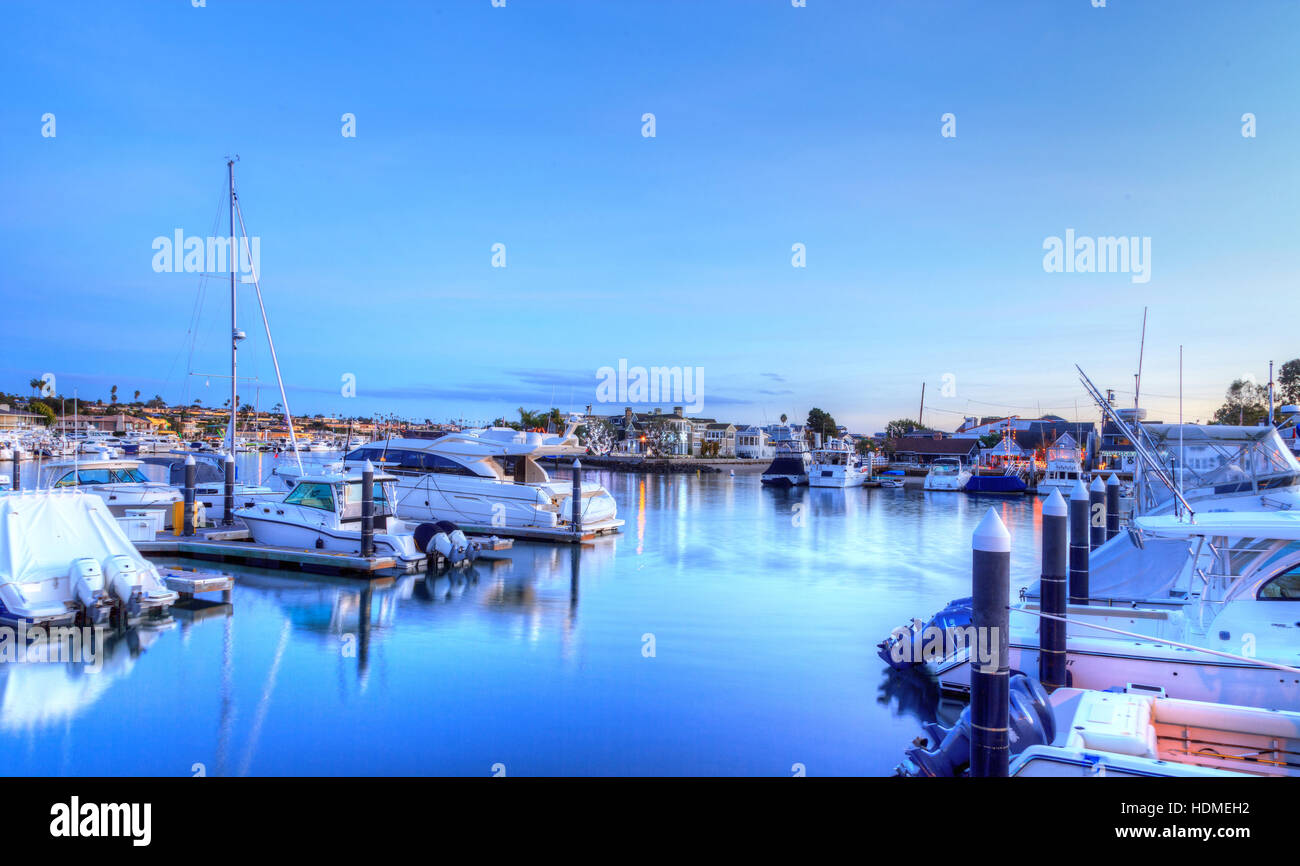 Balboa Island harbor at sunset with ships and sailboats visible from ...