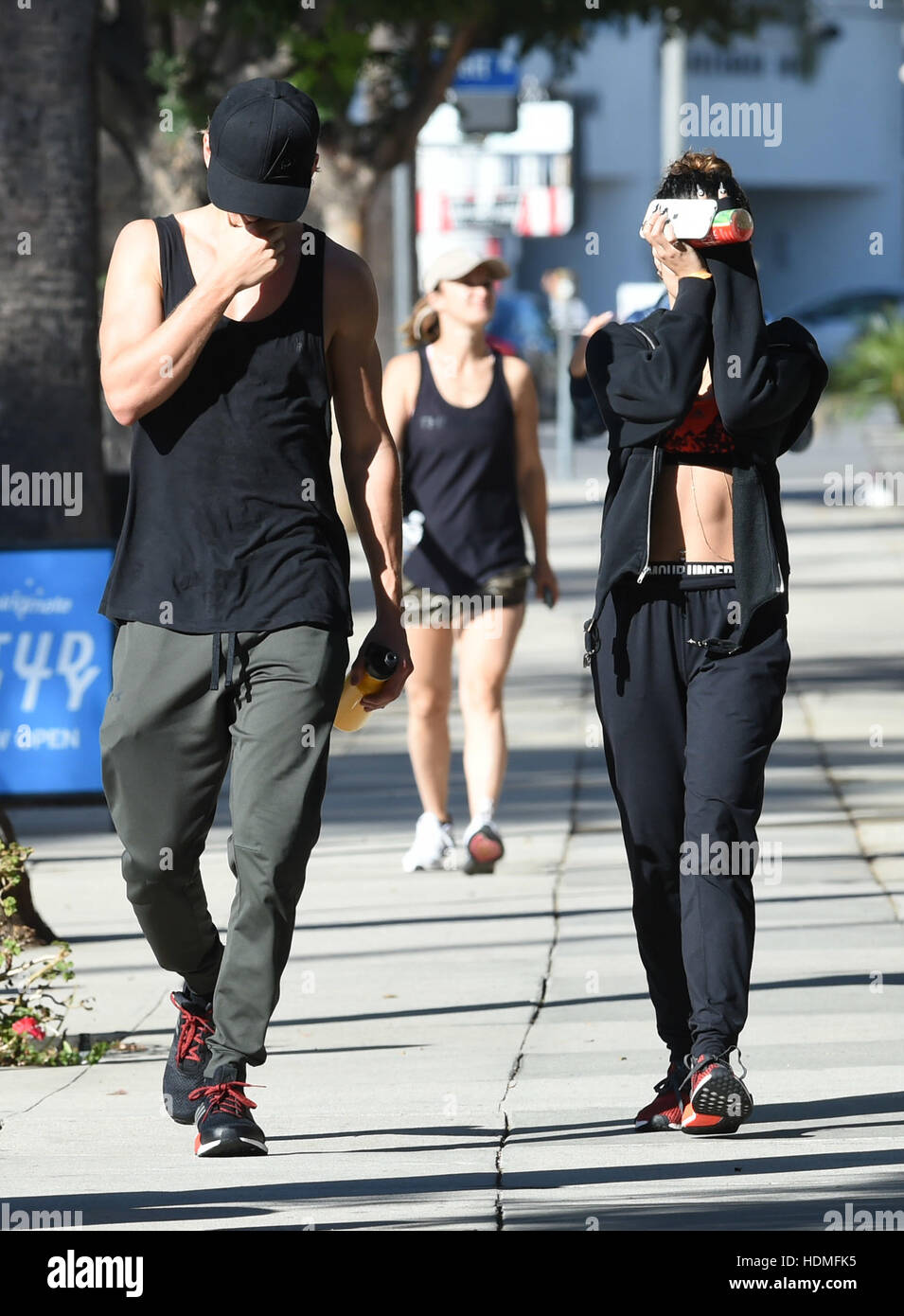 Vanessa Hudgens shows her muscular abs as she hides her face after a ...