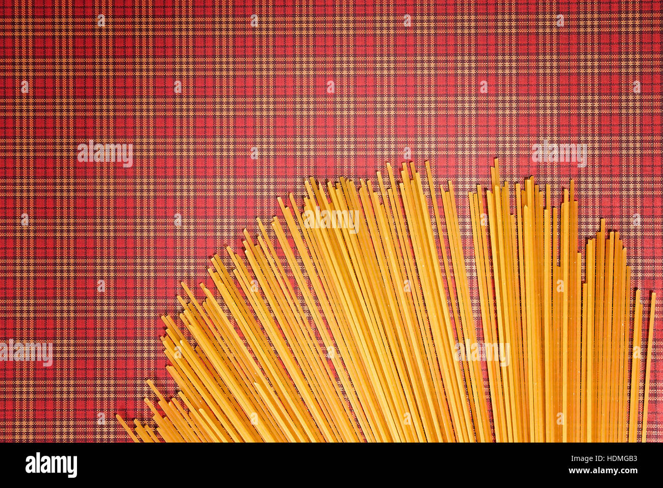 Yellow italian spaghetti pasta on red background Stock Photo - Alamy
