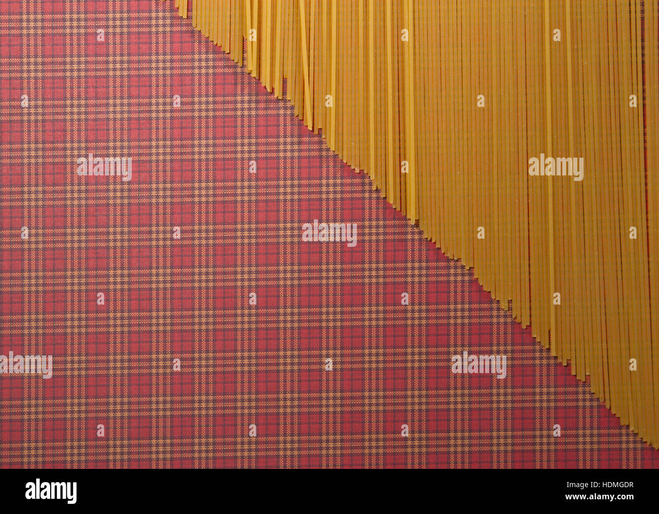 Yellow italian spaghetti pasta on red background Stock Photo - Alamy