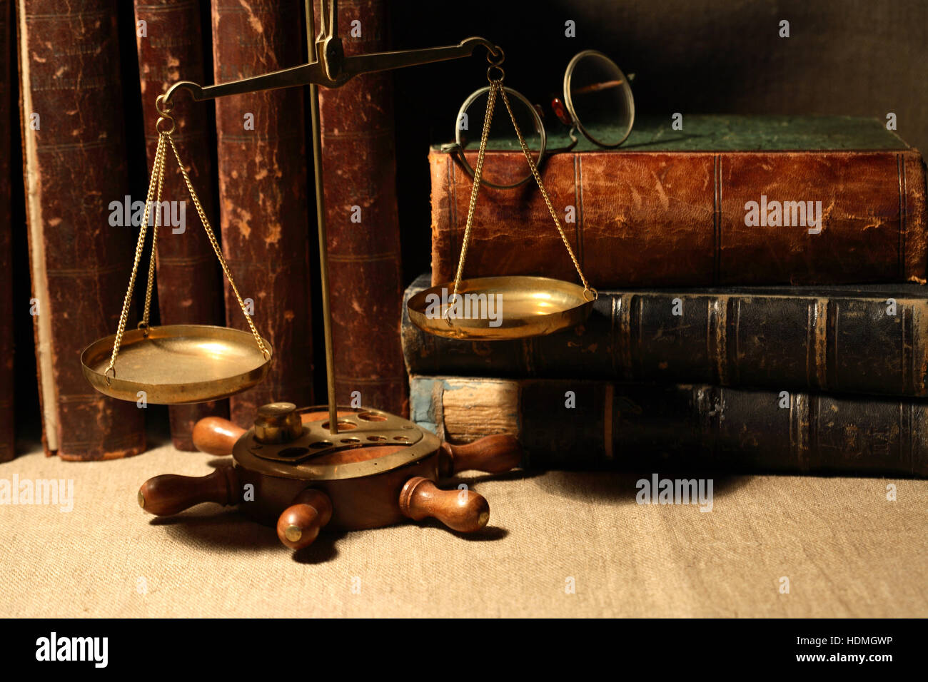 Vintage still life. Old brass weight scale near books and spectacles ...