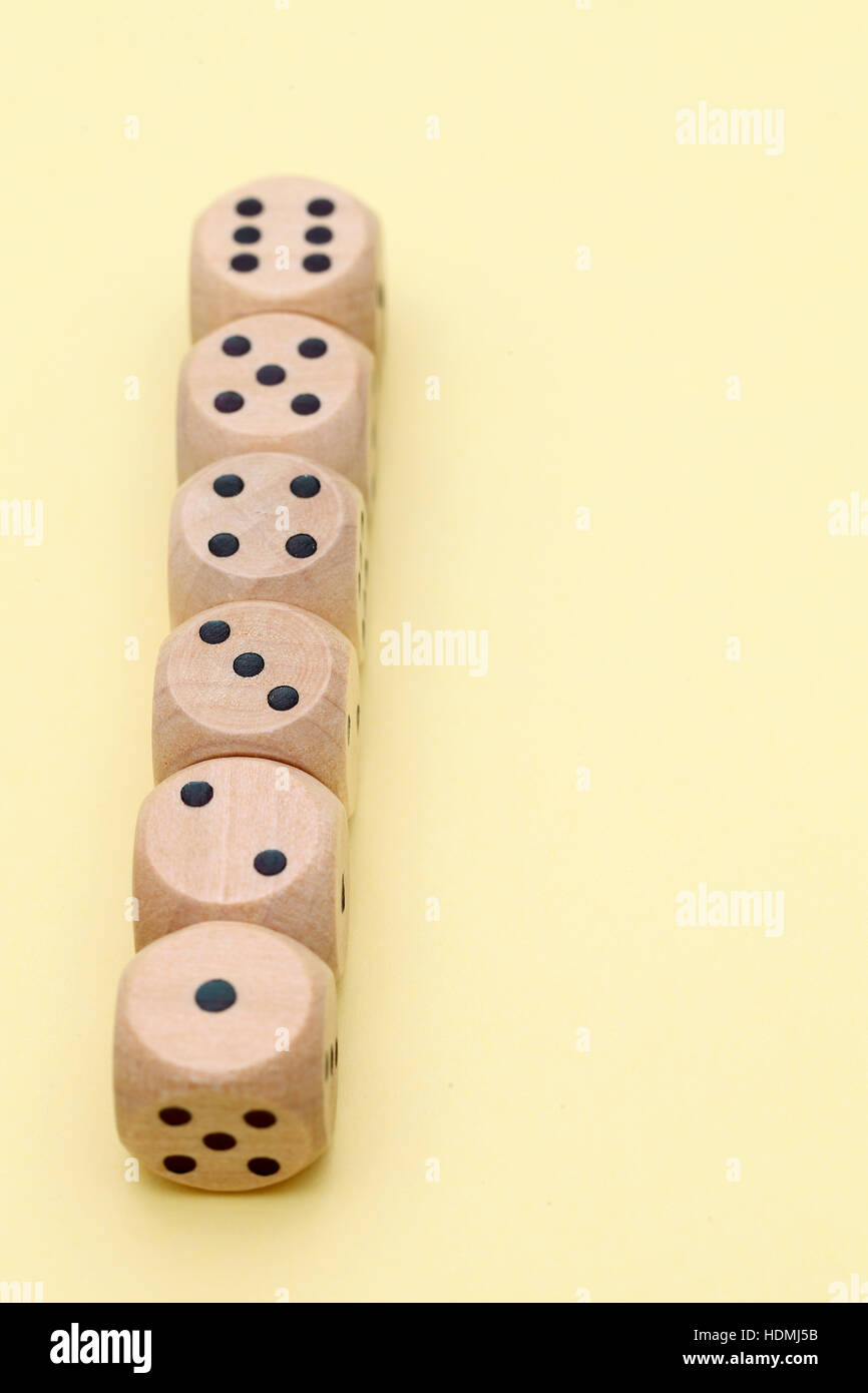 Row of many wooden dice on a yellow background Stock Photo - Alamy