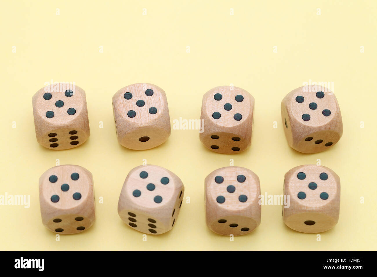 Many wooden dice on a yellow background Stock Photo - Alamy