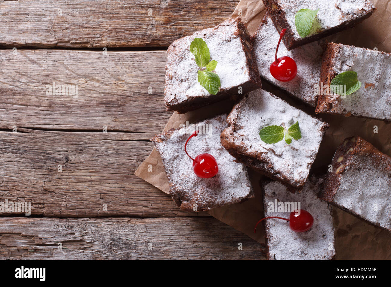 brownie cake with mint and cherry on paper. horizontal view from above ...