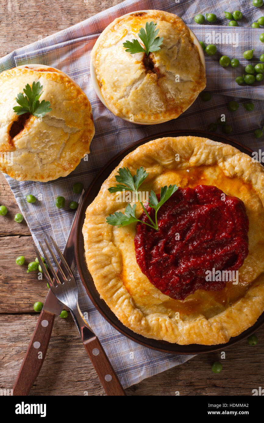 Australian meat pie on the table, a vertical top view, rustic style ...