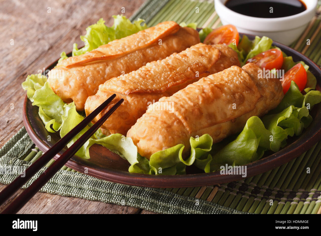 Asian fried spring rolls on a plate and chopsticks close-up. horizontal ...
