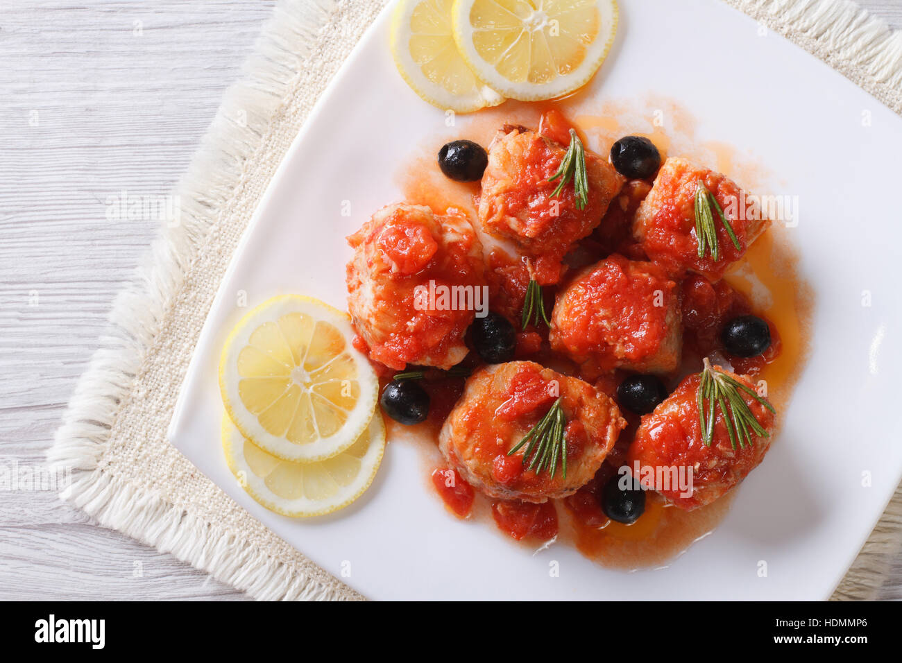 Fish fillet in tomato sauce with olives on the plate. horizontal view ...