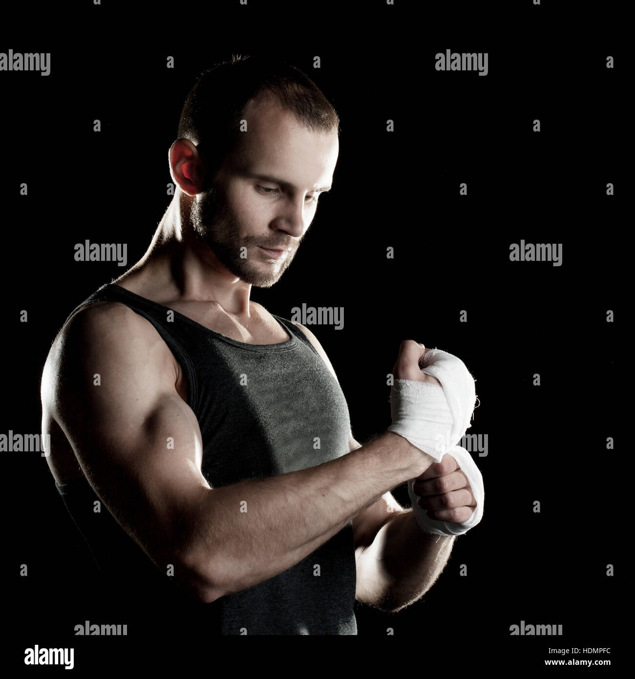 muscular man on a black background, clasps hands in a fist Stock Photo ...