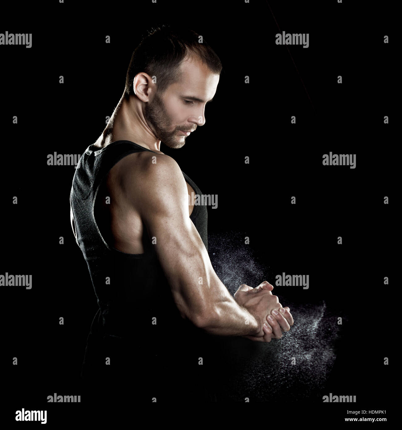 muscular man on a black background, clasps hands in a fist Stock Photo ...