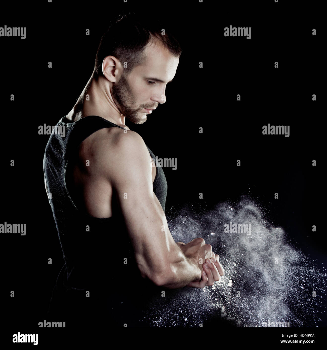 muscular man on a black background, clasps hands in a fist Stock Photo ...