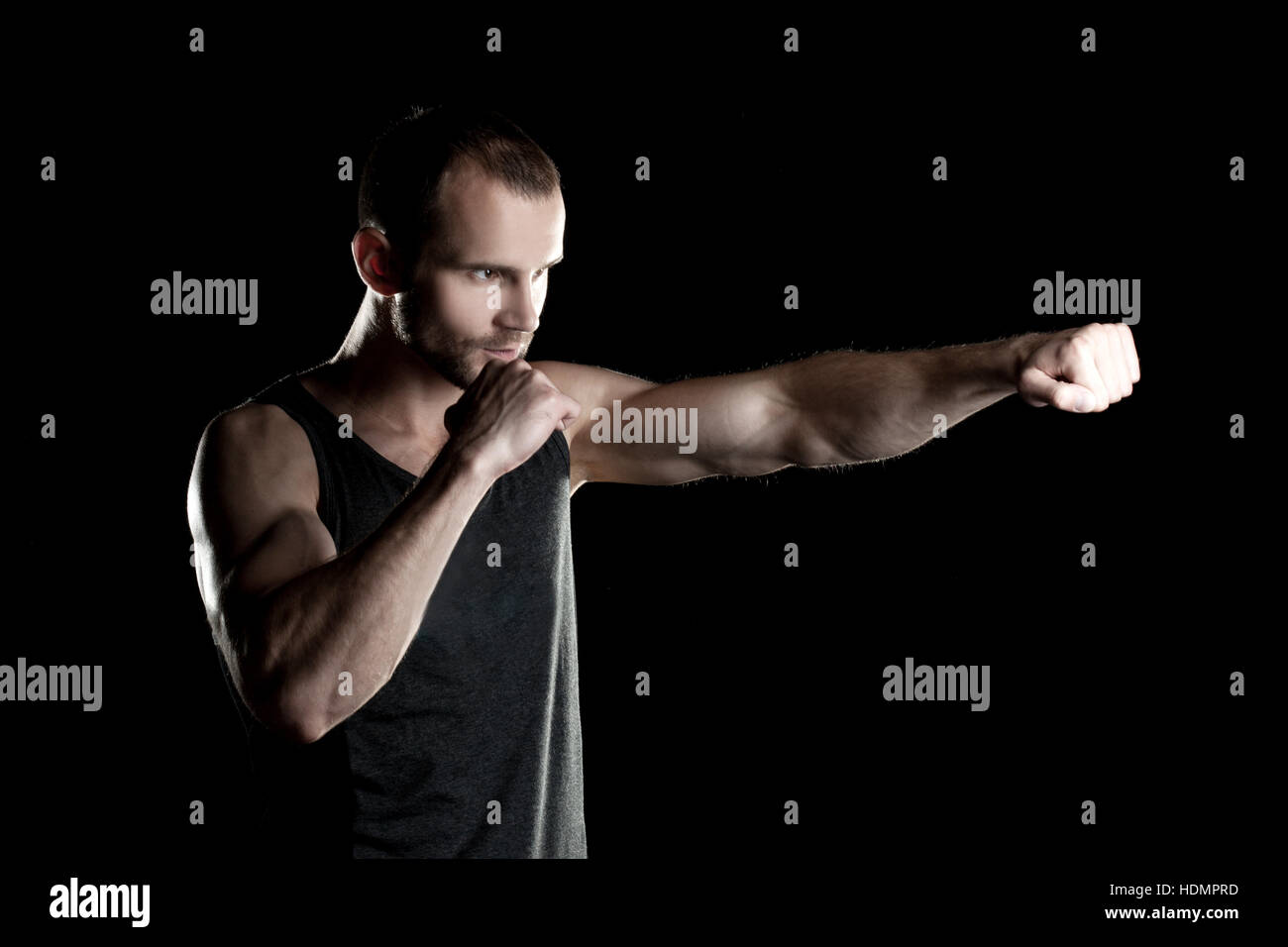 muscular man on a black background, clasps hands in a fist Stock Photo ...