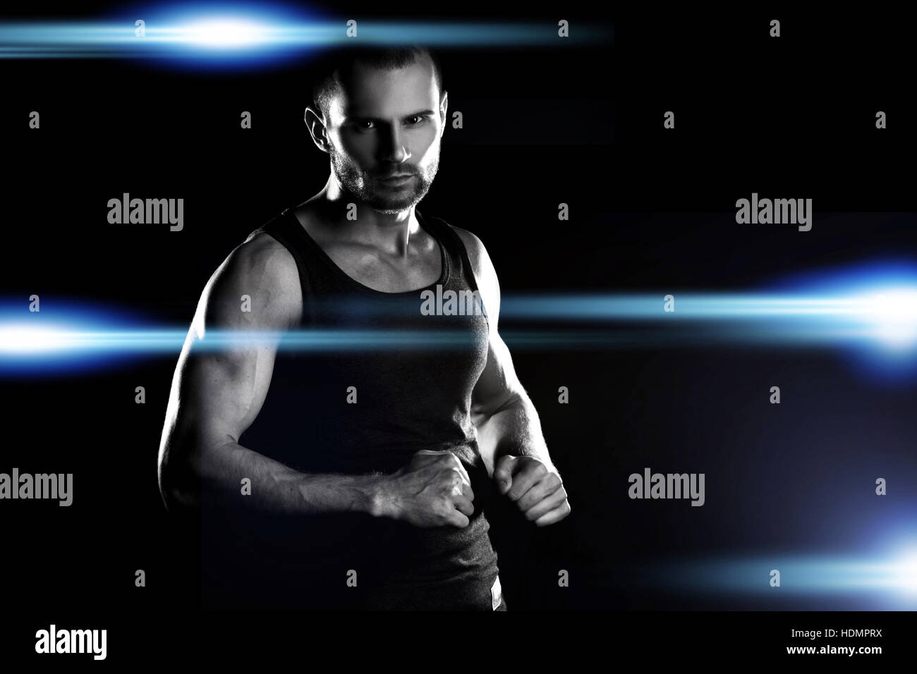 muscular man on a black background, clasps hands in a fist Stock Photo ...