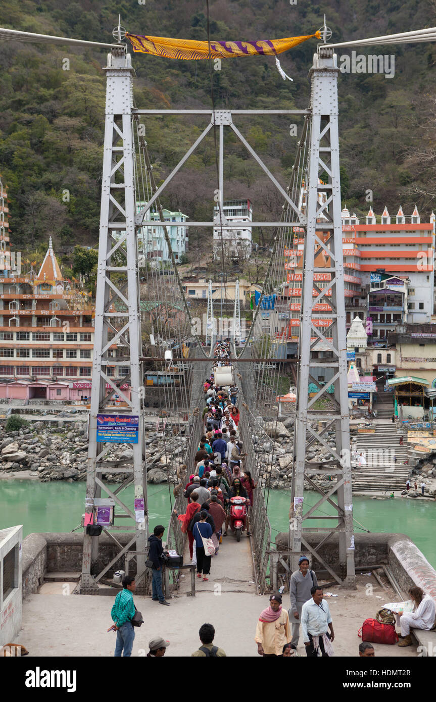 People crossing Laxman Jhula bridge over Ganges river in Rishikesh ...