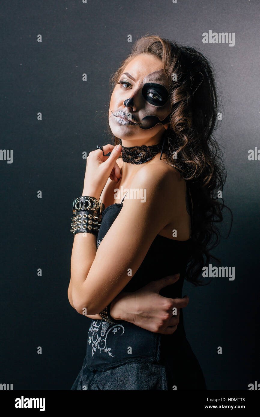 Young woman in black with half face skull make-up Stock Photo - Alamy