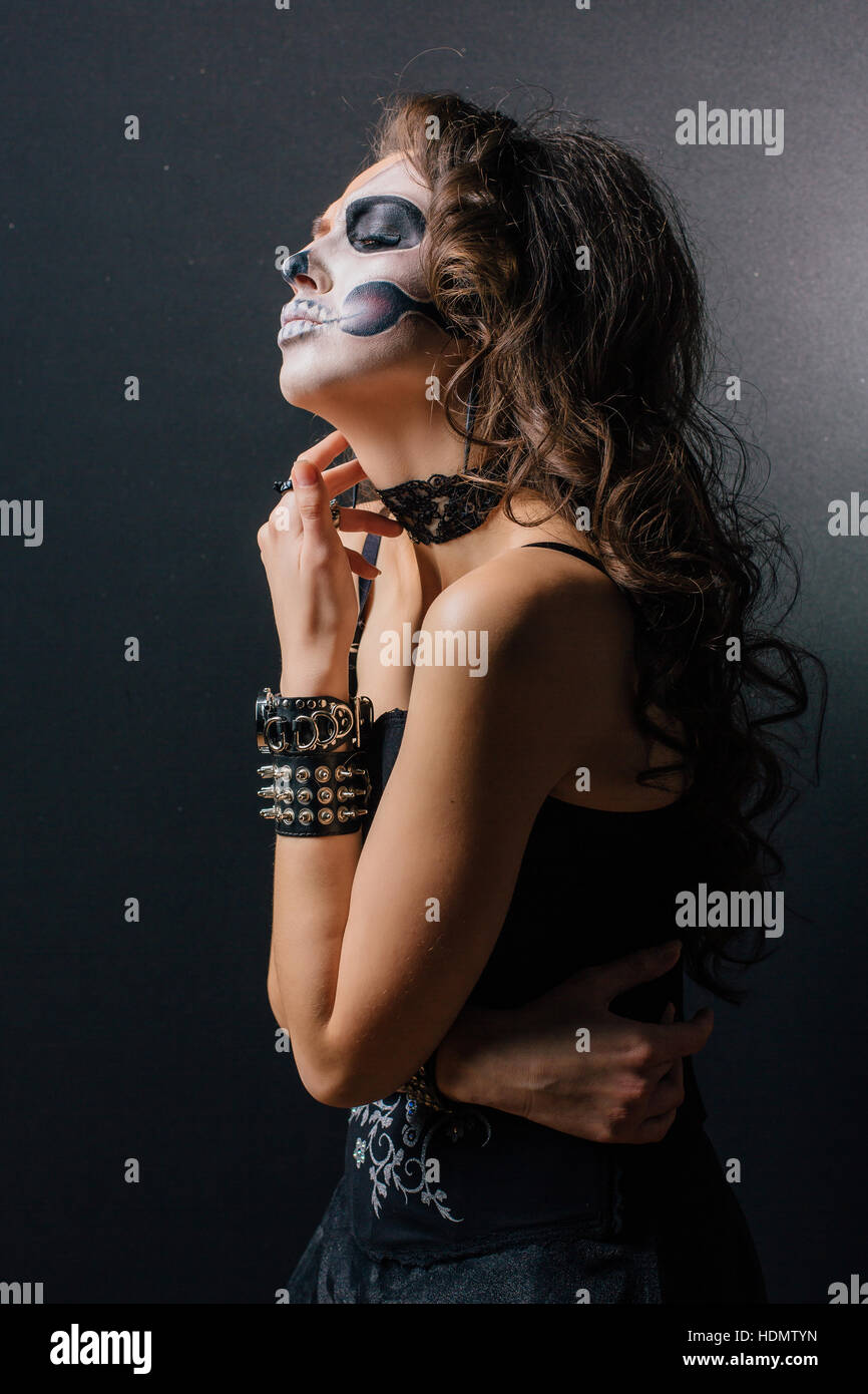 Young woman in black with half face skull make-up Stock Photo - Alamy