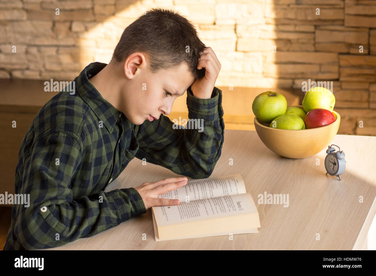 Young Boy Reading Book and Studying on Table at Home Stock Photo - Alamy