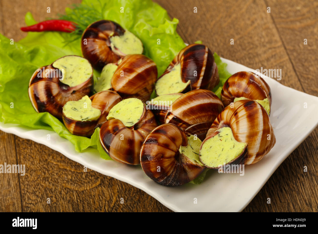 Escargot with cheese cream on salad leaves Stock Photo - Alamy