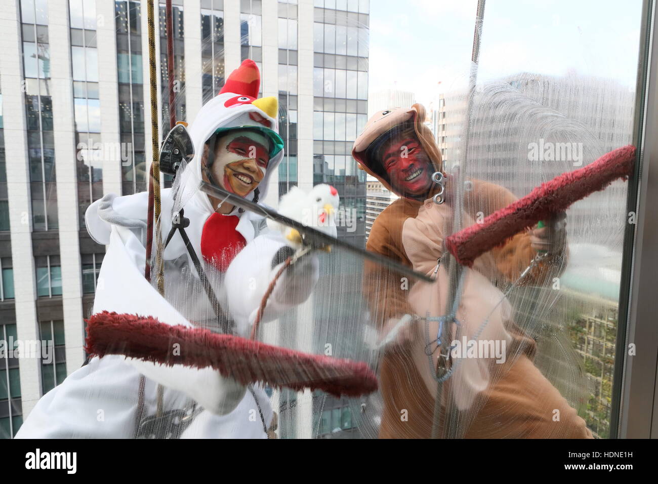Tokyo, Japan, 15th December, 2016. Window cleaners dressed as rooster ...