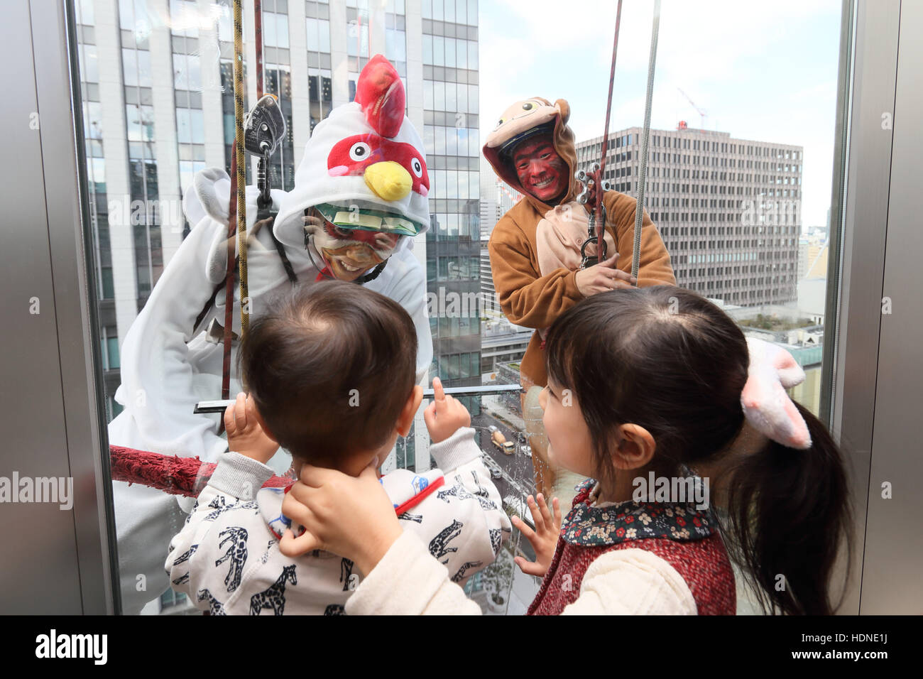 Tokyo, Japan, 15th December, 2016. Window cleaners dressed as rooster ...