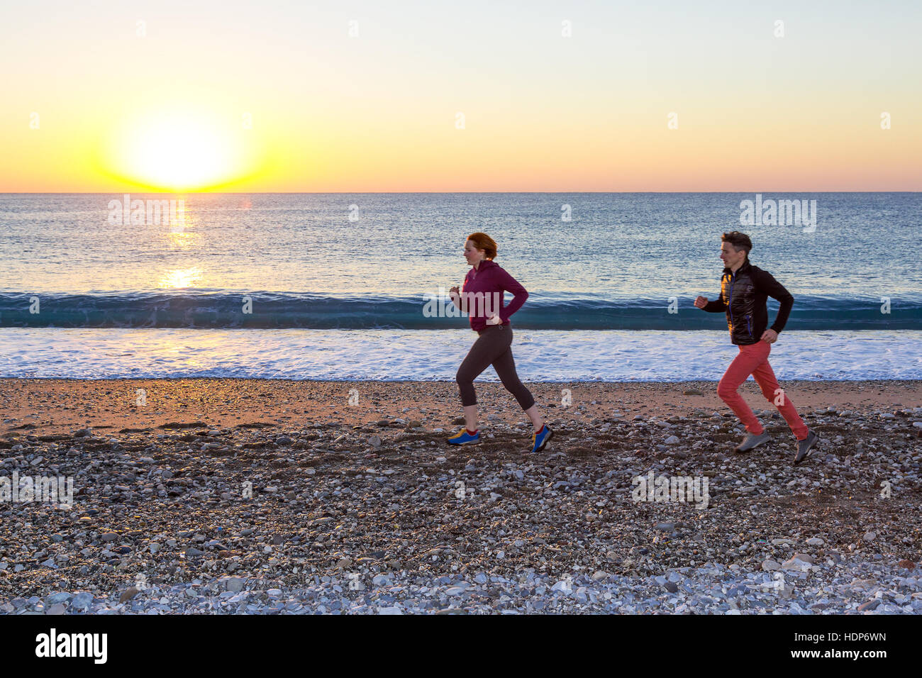 Sporty Couple doing Morning Jogging on Sea Beach at Sunrise Stock Photo ...