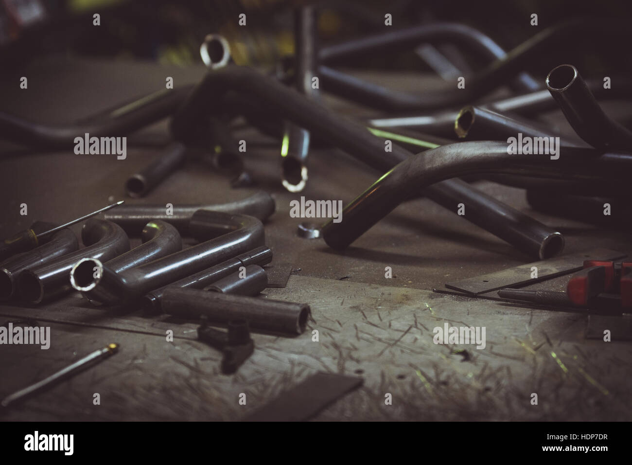 Steel pipe and tools close up on a work surface in a metalwork ...