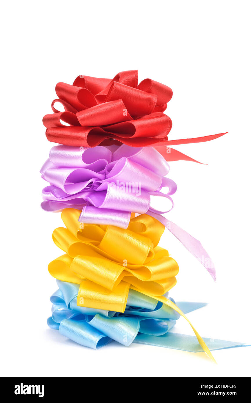 a stack of satin gift ribbon bows of different colors on a white ...