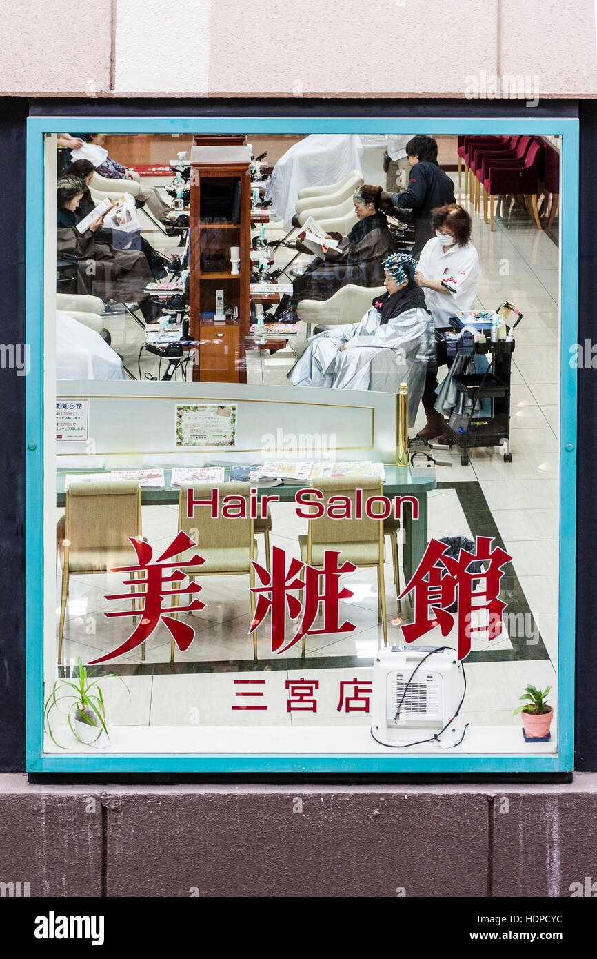 View through framed window of a Japanese ladies hair saloon with women ...