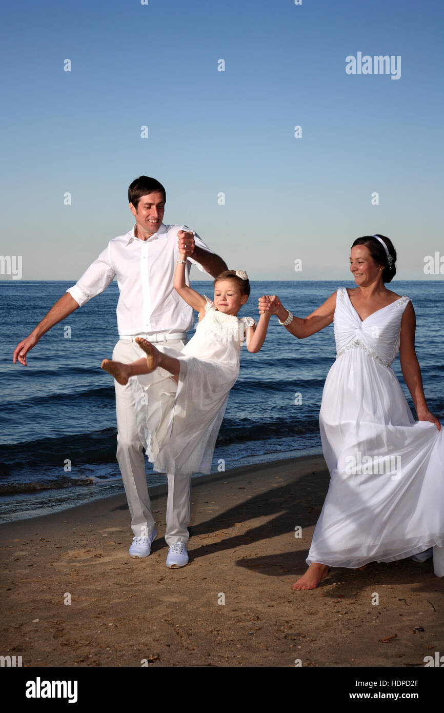 bride and groom with their kid at the beach Stock Photo - Alamy