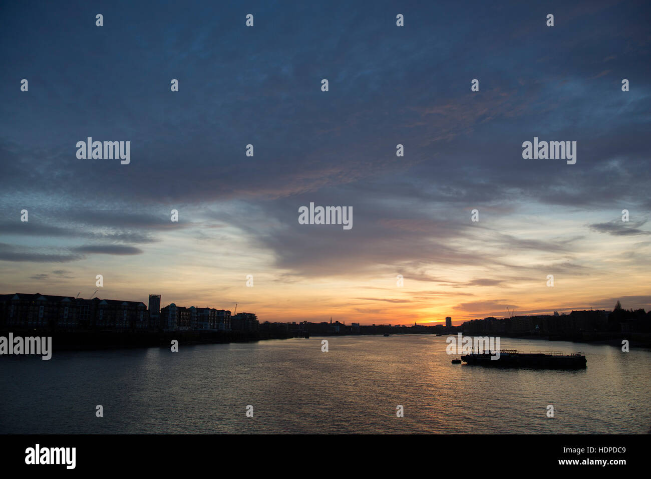 Golden sky at sunset looking over the River Thames at Wapping in East ...