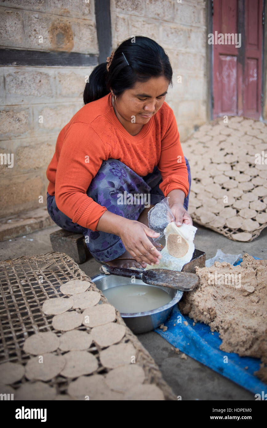 A local Burmese woman preparing traditional Ngapi, a Fermented beans ...
