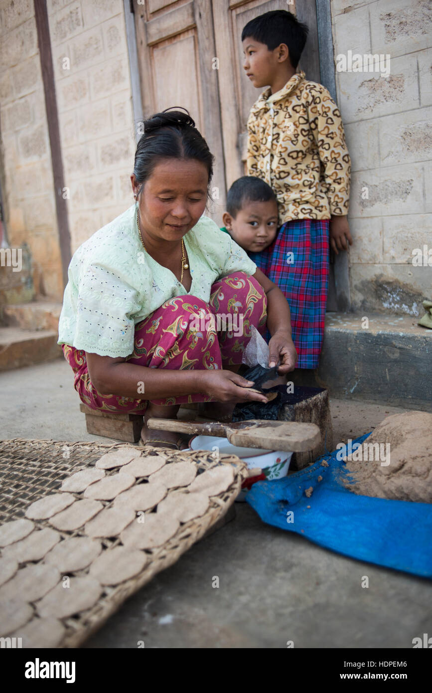 A local Burmese woman preparing traditional Ngapi, a Fermented beans ...