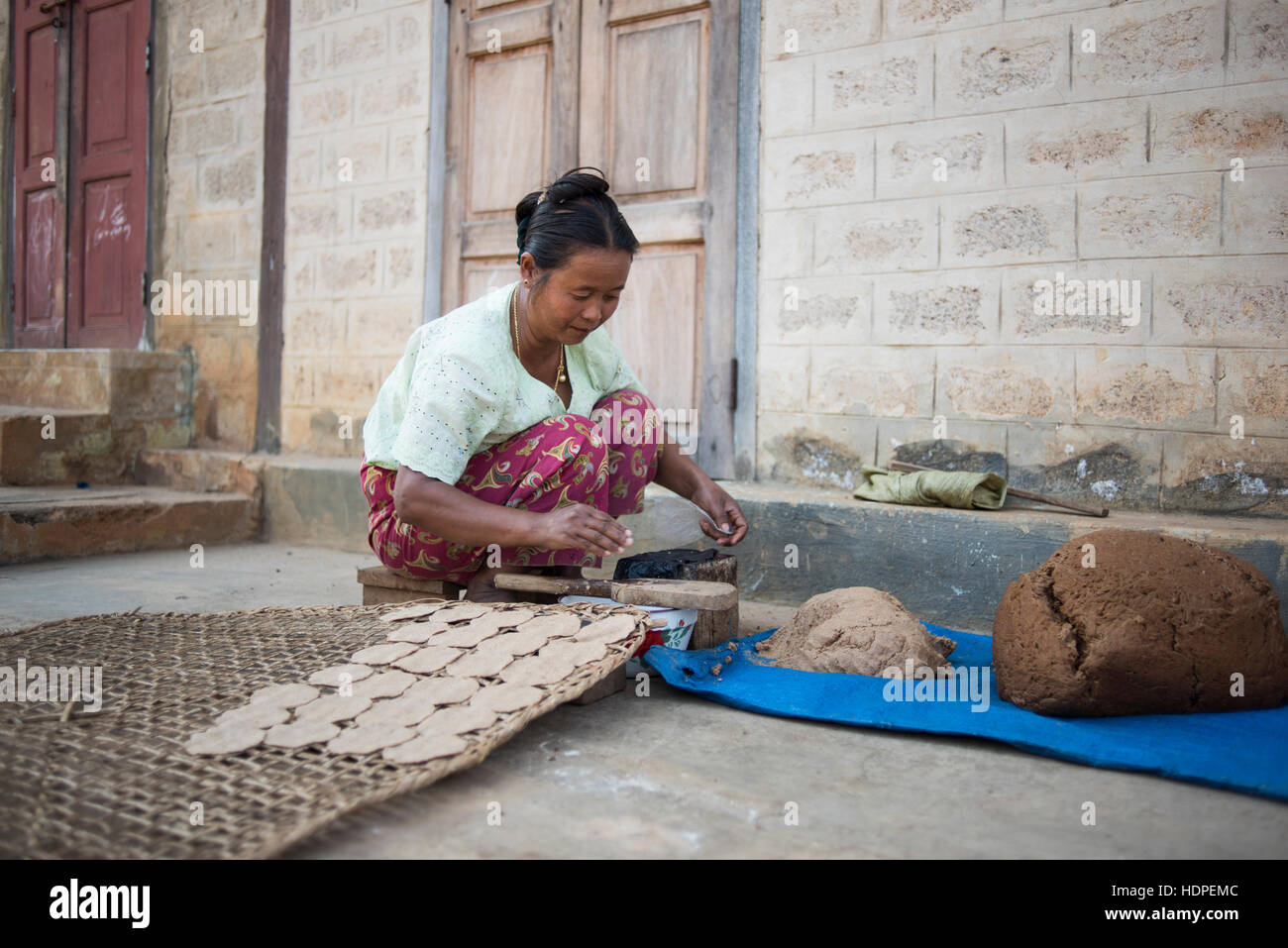 A local Burmese woman preparing traditional Ngapi, a Fermented beans ...