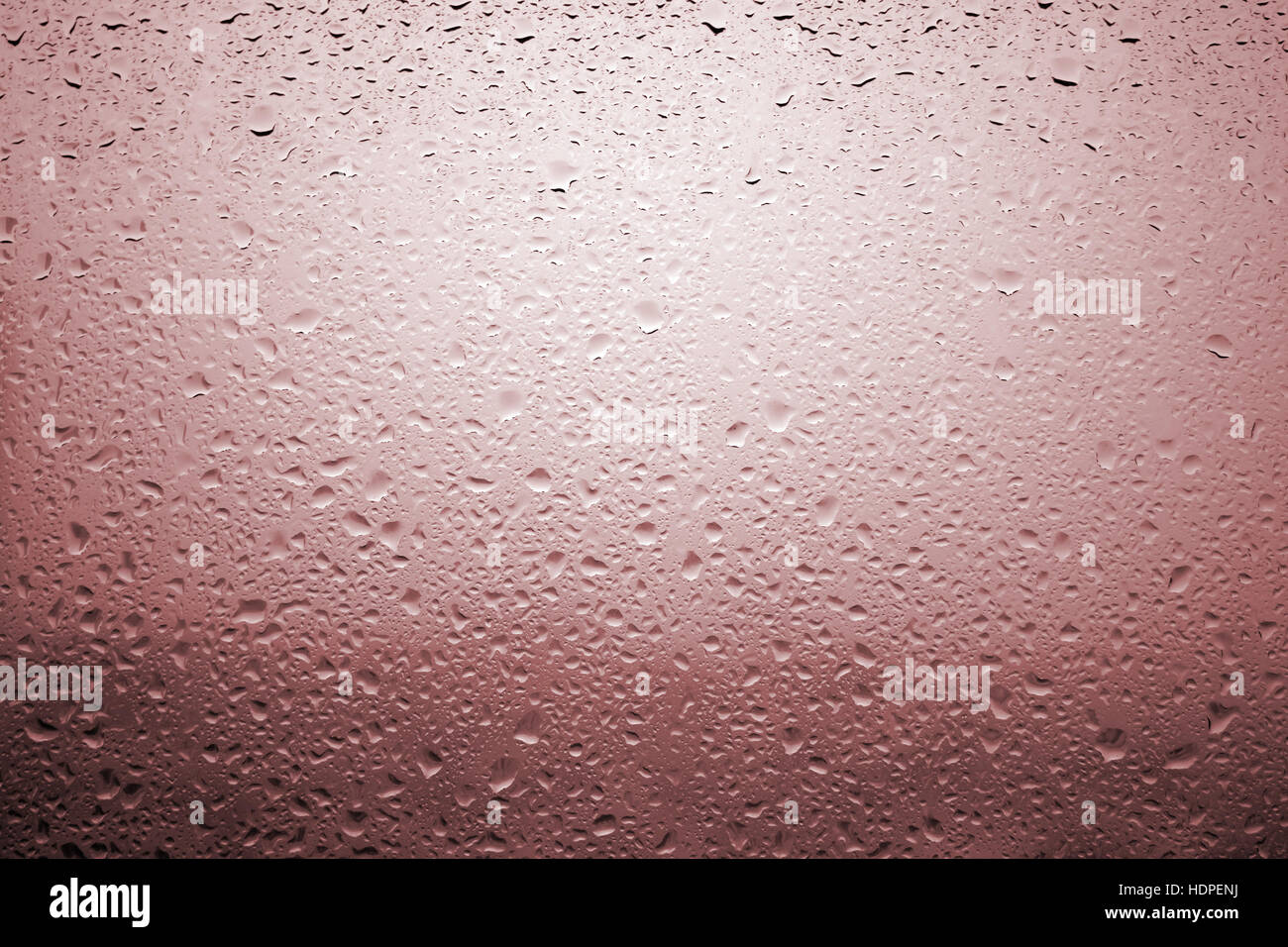 Drops of rain on a window glass with very diffuse landscape reddish ...