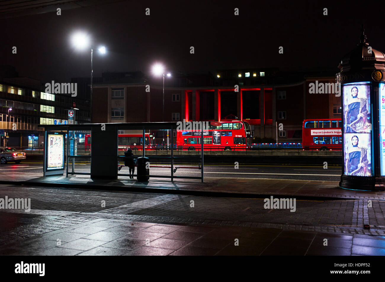 Lone woman at night in Croydon bus stop Stock Photo - Alamy