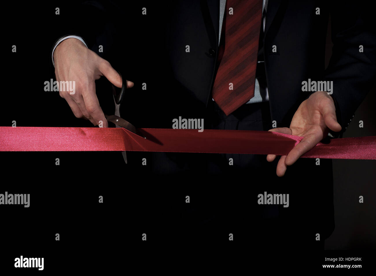 man in a suit, cuts a red tape, opening of event Stock Photo - Alamy