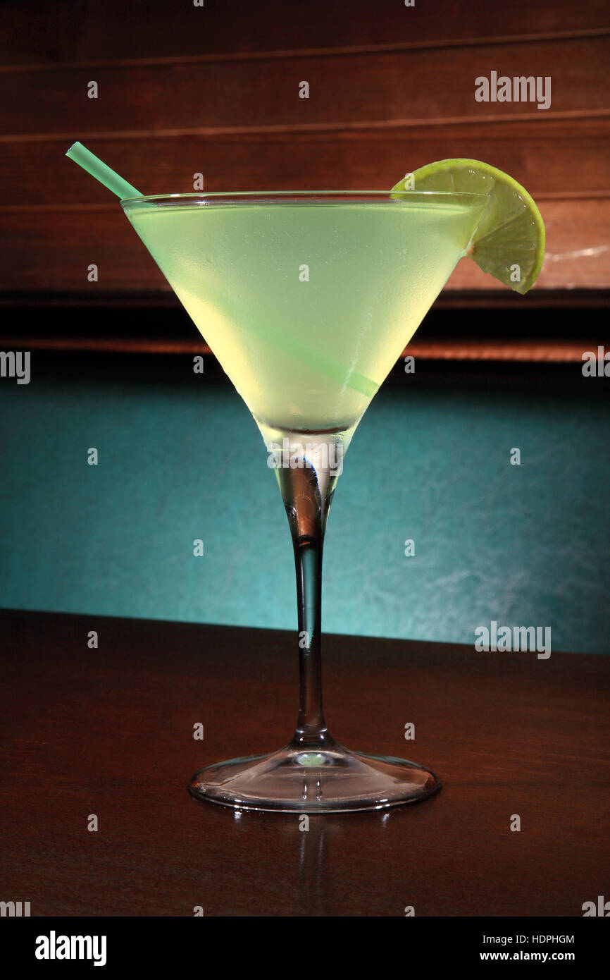 appletini cocktail with lime wheel, vodka, pineapple juice, liqueur in ...